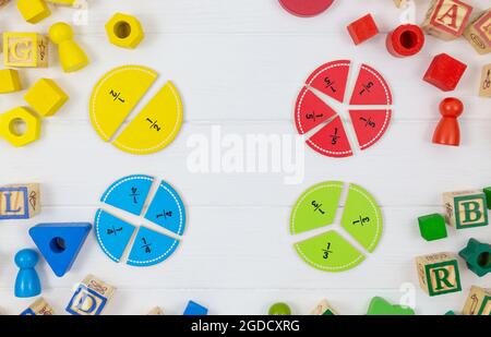 Multicolored fractions, blocks, notebook on white wooden table. Back to ...