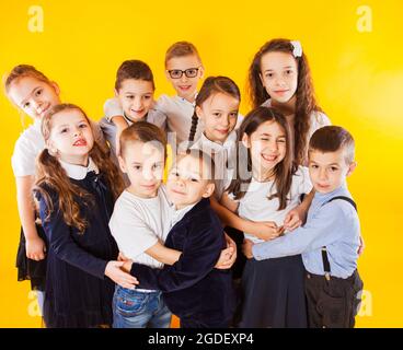 The friendly classmates are hugging on a yellow background Stock Photo ...