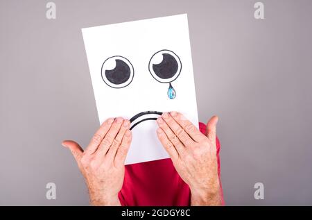 Man behind a paper with a sadness expression Stock Photo - Alamy