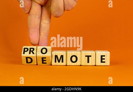 Promote or demote symbol. Businessman turns cubes and changes the word ...