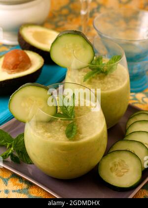 Fresh cucumber slices and mint leaves on a blue background, overhead ...