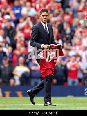 Manchester United's Raphael Varane holds up his shirt on the pitch as ...