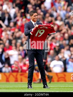 Manchester United's Raphael Varane holds up his shirt on the pitch as ...