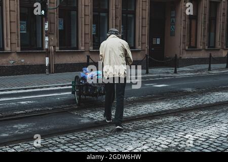 man pushing a cart with loads, street photography Stock Photo - Alamy