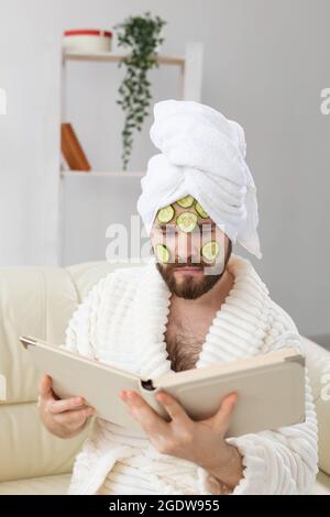 Funny male model with clay mask and cucumber slices on face. Spa ...