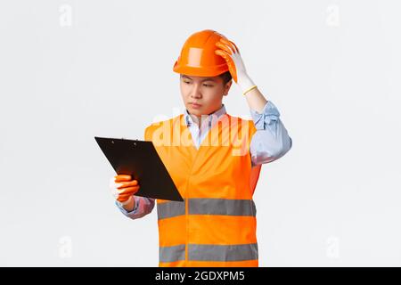 Asian man wearing reflective jacket holding checklist paper standing in ...