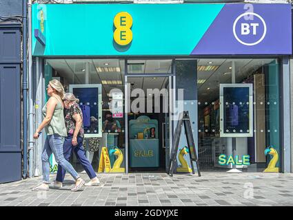 Shoppers walk past EE, BT Mobile Communications Store on Bow Street in ...