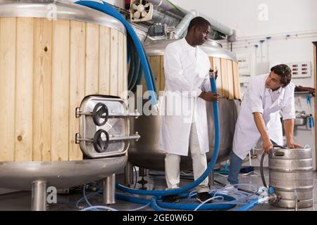 Brewers working on his workplace in the brew-house Stock Photo - Alamy