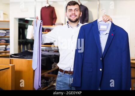 adult owner guy displaying jacket in fashion store Stock Photo - Alamy