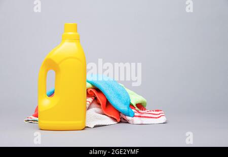 Laundry detergent and towels on table against pink background Stock ...
