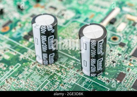Close shot of 2 large size aluminium electrolytic capacitors on pcb ...