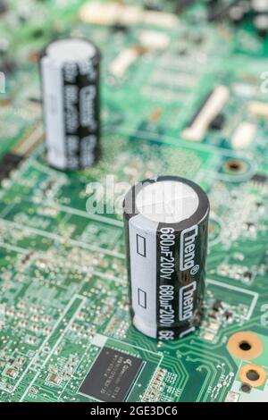 Close shot of 2 large size aluminium electrolytic capacitors on pcb ...