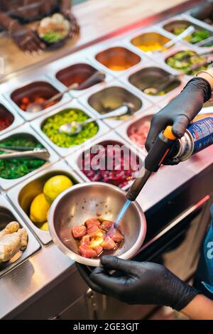 Unrecognized restaurant worker wearing latex gloves using a knife to ...