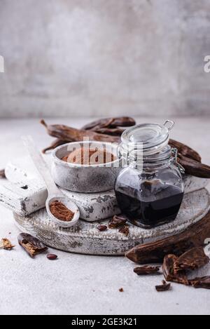 Carob pods, powder and molasses or syrup Stock Photo - Alamy