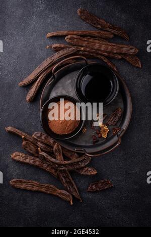 Carob pods, powder and molasses or syrup Stock Photo - Alamy