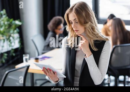 What do you think of this. colleagues working on a digital tablet in an ...