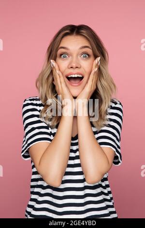 Shocked face of woman shouting WOW, isolated on studio background with ...