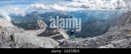 Hiker with helmet at the summit of the Watzmann, view over mountains ...