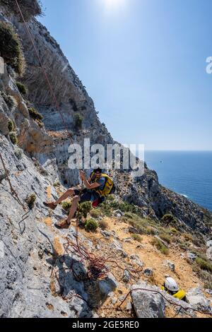 Man abseiling rock face Stock Photo - Alamy