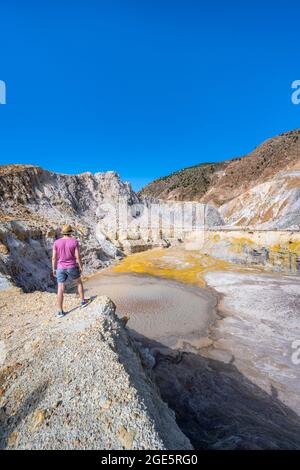 Young tourist at a crater, volcano caldera with pumice fields, yellow ...