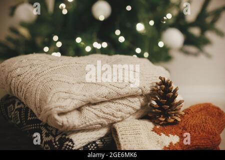 Cozy knitted sweaters and wool socks on rustic wood with pine cone on ...