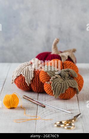 Cute crochet knitted orange pumpkins on black background with a ball of ...