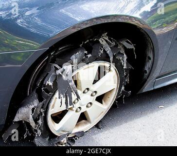 Destroyed blown out tire with exploded, shredded and damaged rubber on ...