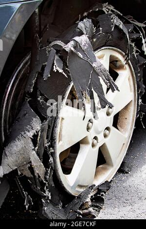 Destroyed blown out tire with exploded, shredded and damaged rubber on ...