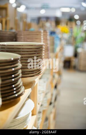 Plates displayed on shelving in household goods store Stock Photo - Alamy