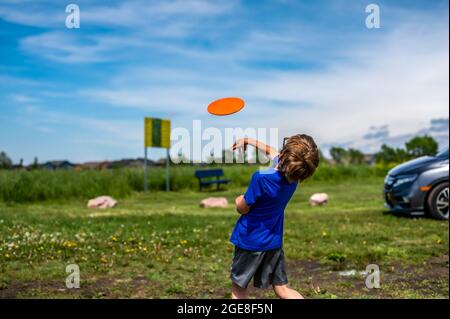 Caucasian child playing disc golf and making the first toss Stock Photo ...