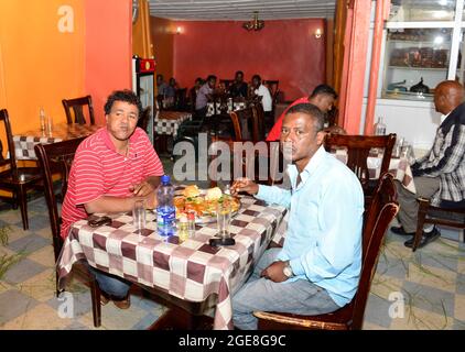 Ethiopian men enjoying eating Injera together at the Elsa Shiro ...