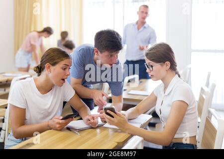 Fellow students having group work tasks during school class Stock Photo ...