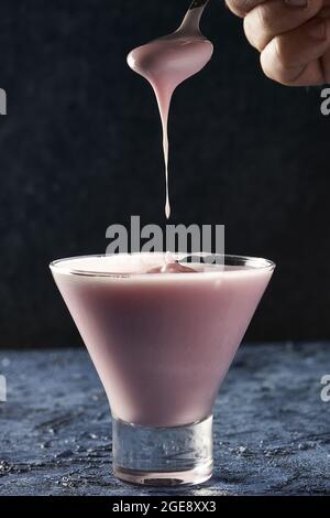 scooping yogurt with a spoon in pink background Stock Photo - Alamy