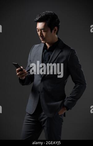 Successful Chinese businessman using smartphone Stock Photo - Alamy