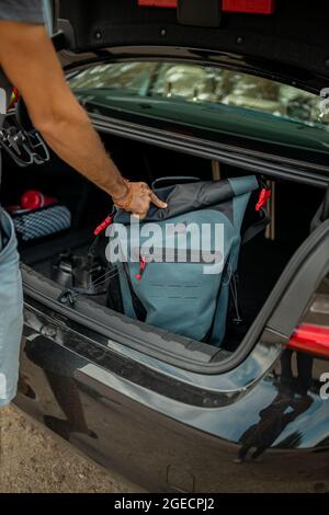Handsome man getting ready for a vacations, loading his backpack in a ...