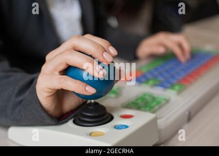 An unrecognizable woman with cerebral palsy is typing on the keyboard ...
