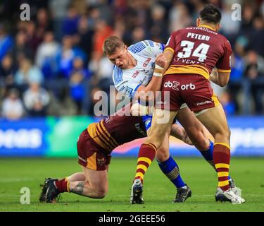 Tom Holroyd of Leeds Rhinos is tackled by Benjamin Garcia of Catalan ...