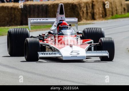 McLaren M23 Grand Prix car racing up the hill climb at the Goodwood ...