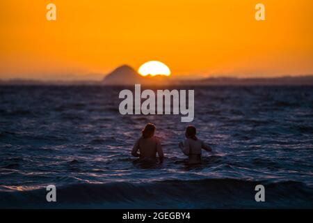 Wild swimmers enjoy the sunrise behind North Berwick Law on Portobello ...