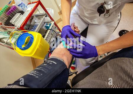 Blood test being performed on a middle aged man's arm / blood being ...