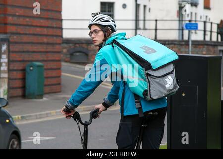 A Deliveroo takeaway bicycle rider with food delivery thermal bag in ...