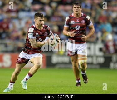 John Bateman (13) of Wigan Warriors offloads the ball despite the ...
