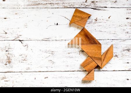 Tangram puzzle in happy running man shape on old white wood background ...