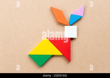 Color tangram puzzle in rabbit shape on wood background Stock Photo - Alamy