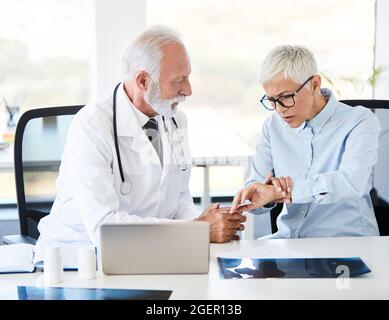 Senior woman sitting at doctor appointment doing ok gesture shocked ...