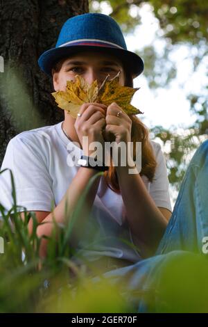 Defocus hello autumn. Female hand in yellow knitted pullover outside in ...