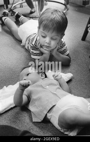 A child in a diaper lies on white bed. Taking care of the baby ...