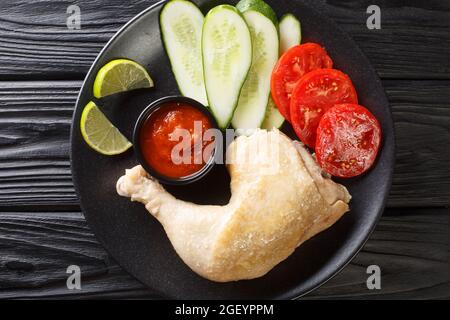 Tasty Ayam pop chicken with vegetables and sauce close up in the plate ...