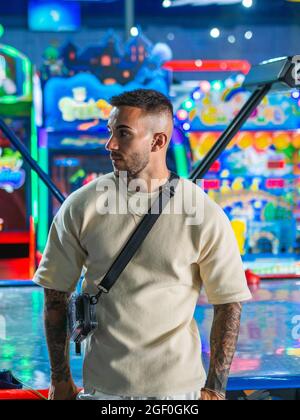 An attractive cool Spanish man with tattoos using his phone while ...
