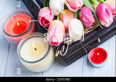 Yellow and pink aroma candles with tulips in dark wooden oriental box ...
